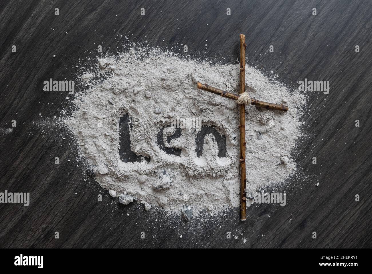 word lent written in ashes with a simple wood cross as the letter t on ...