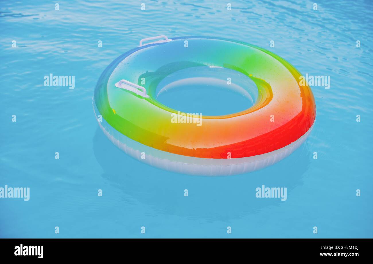 Floating ring on blue water pool with waves reflecting in the summer ...