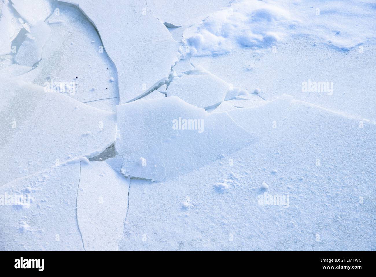 Snow and broken ice on a frozen lake surface, natural winter background ...
