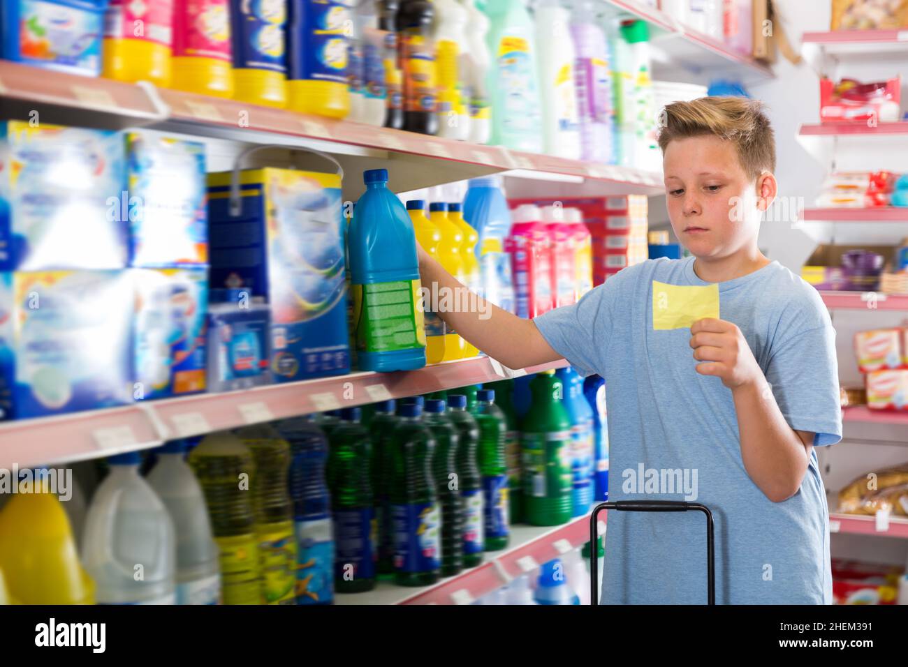 Focused positive boy looking at shopping list Stock Photo - Alamy