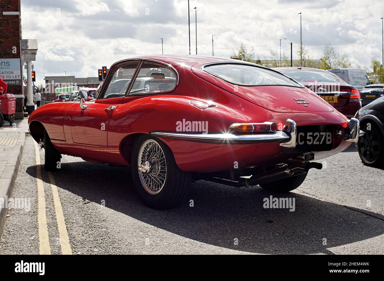 Rear view of a red E-Type Jaguar sports car driving away Stock Photo ...