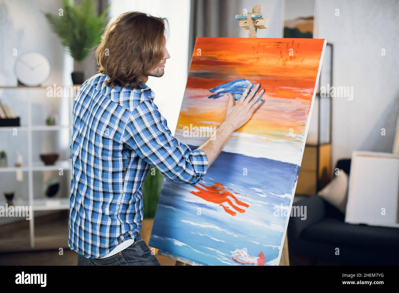 Creative male person painting on canvas with hands at bright art studio ...