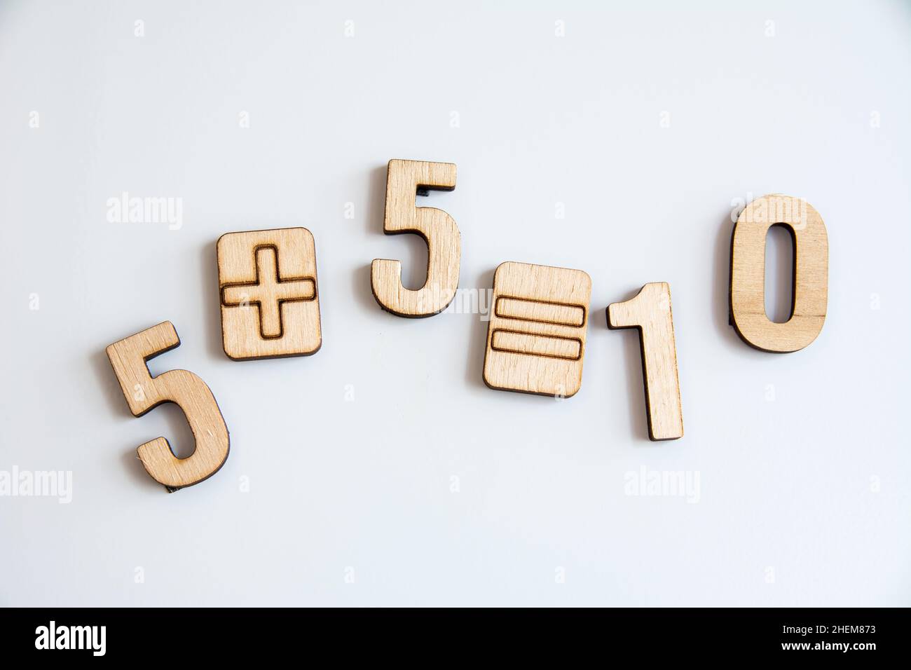 Wooden numbers symbols on white background. Arithmetic, five plus five ...