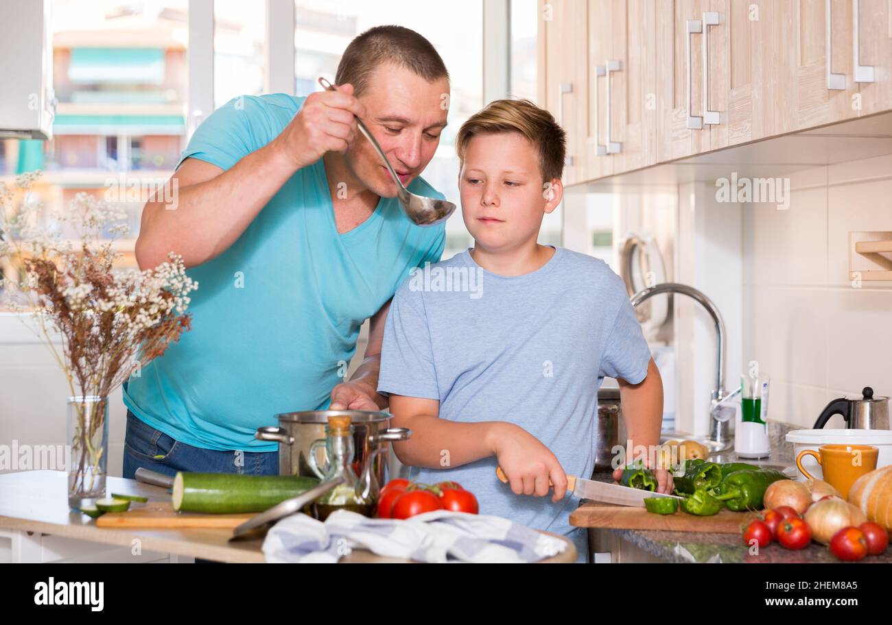 Boy and his father are cooking soup together in the kitchen Stock Photo ...