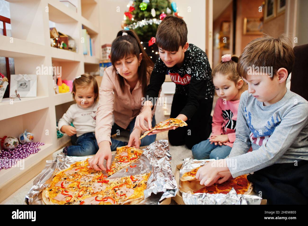 Happy family with four kids eating pizza at home Stock Photo - Alamy