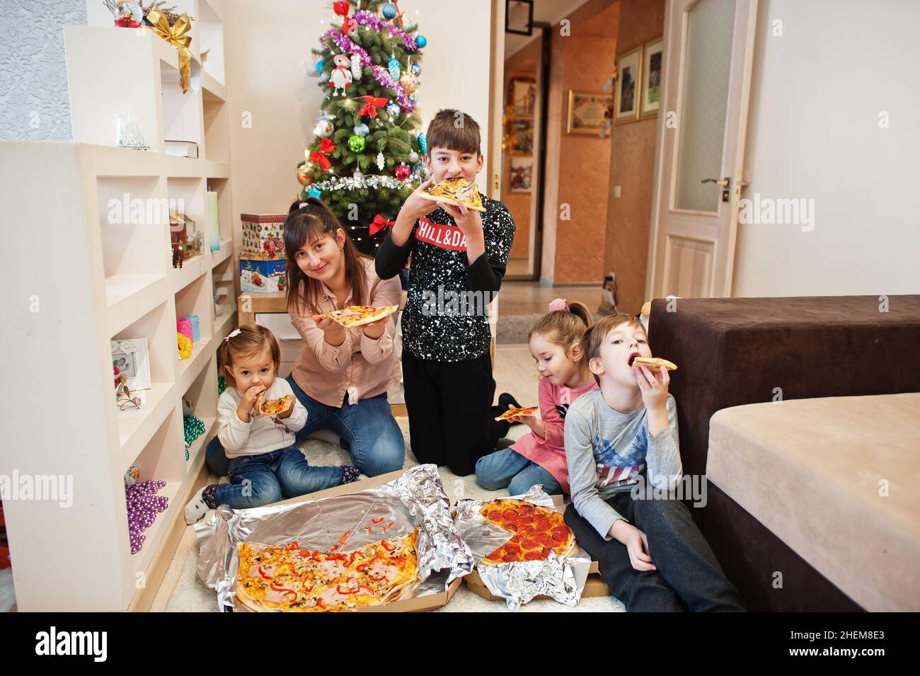 Happy family with four kids eating pizza at home Stock Photo - Alamy