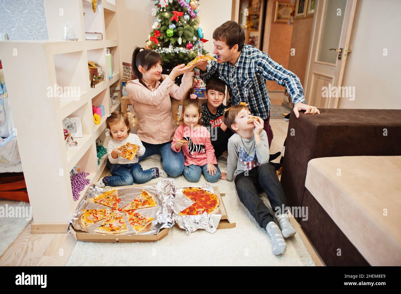Happy family with four kids eating pizza at home Stock Photo - Alamy