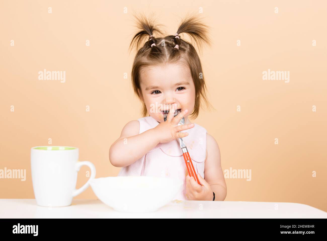 Babies eating, healthy food for a baby. Smiling baby girl with spoon on ...