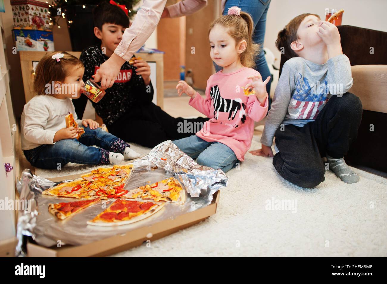 Happy family with four kids eating pizza at home Stock Photo - Alamy