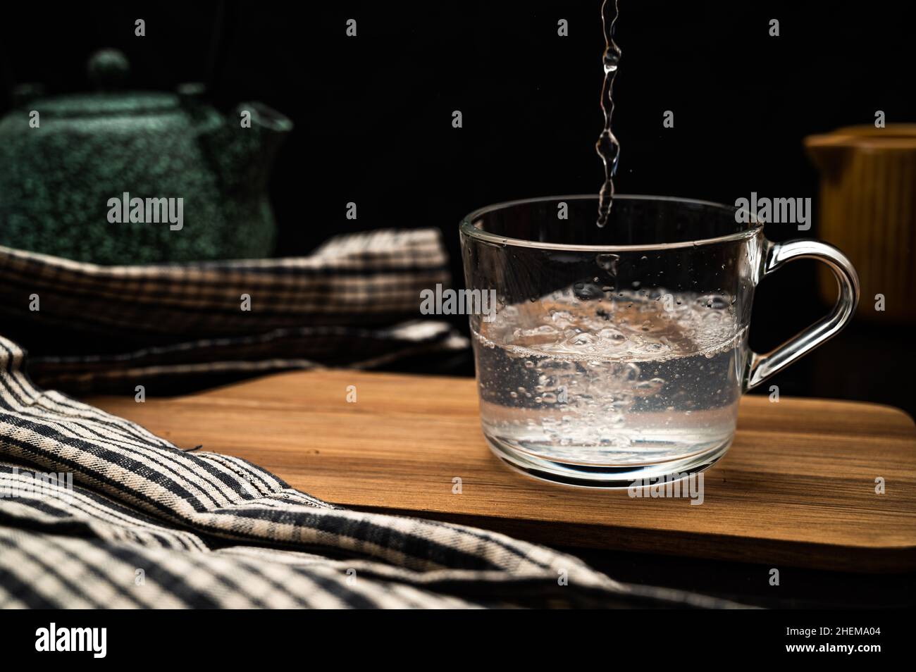 Healthy tea poured into transparent cup. Teapot, lemon, ginger ...