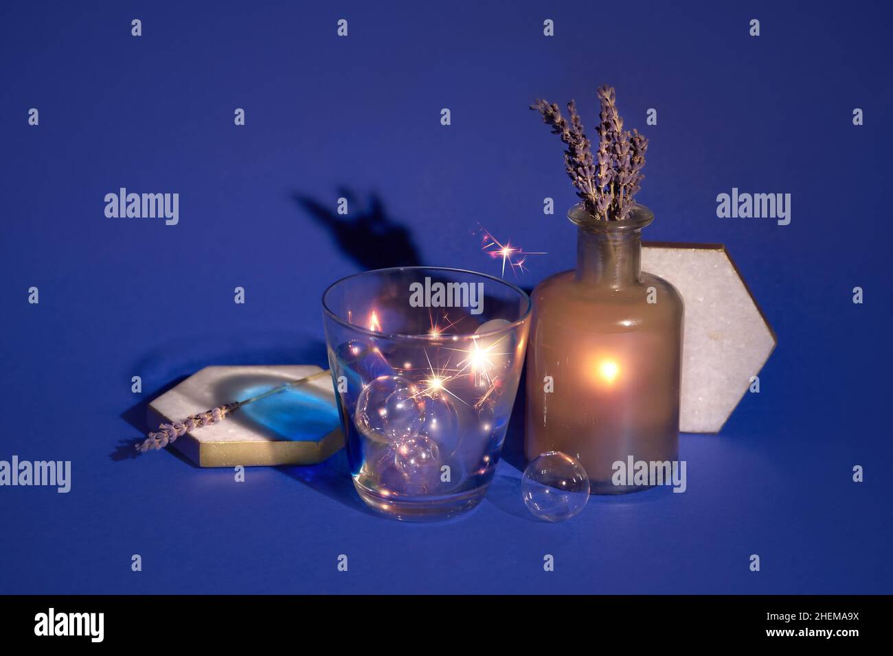 Dry lavender in glass, magic light with sparkles and orange glow. Dark ...