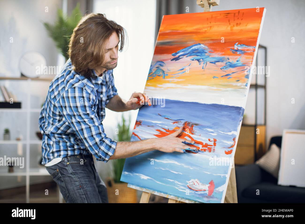 Creative male person painting on canvas with hands at bright art studio ...