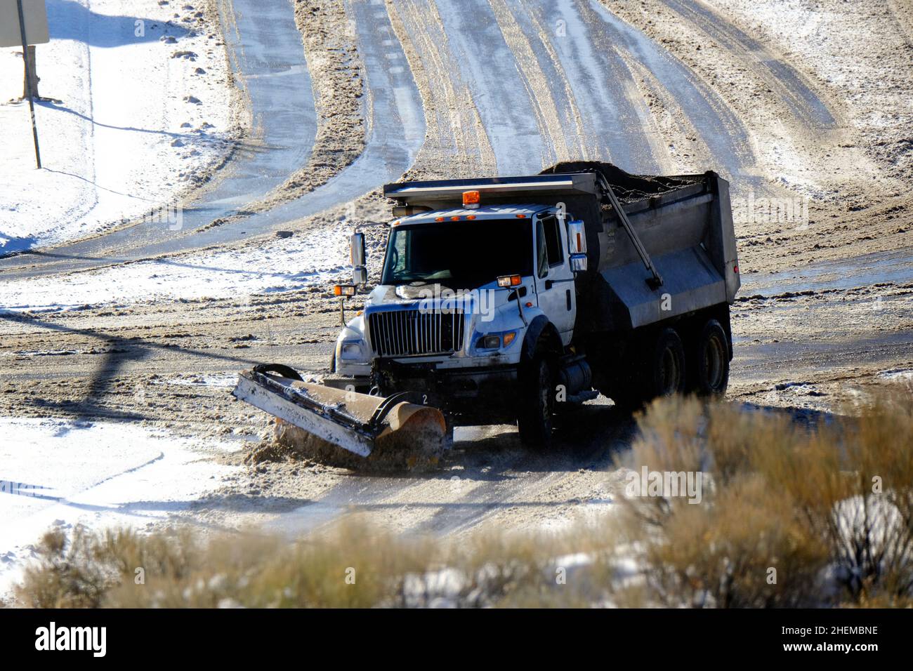 Snow plow truck driving on wintry snowy road clearing a path for ...