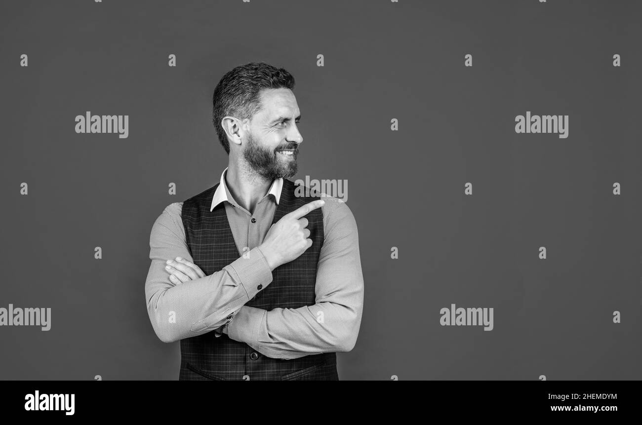 Look at this. Happy man point index finger red background. Objective ...