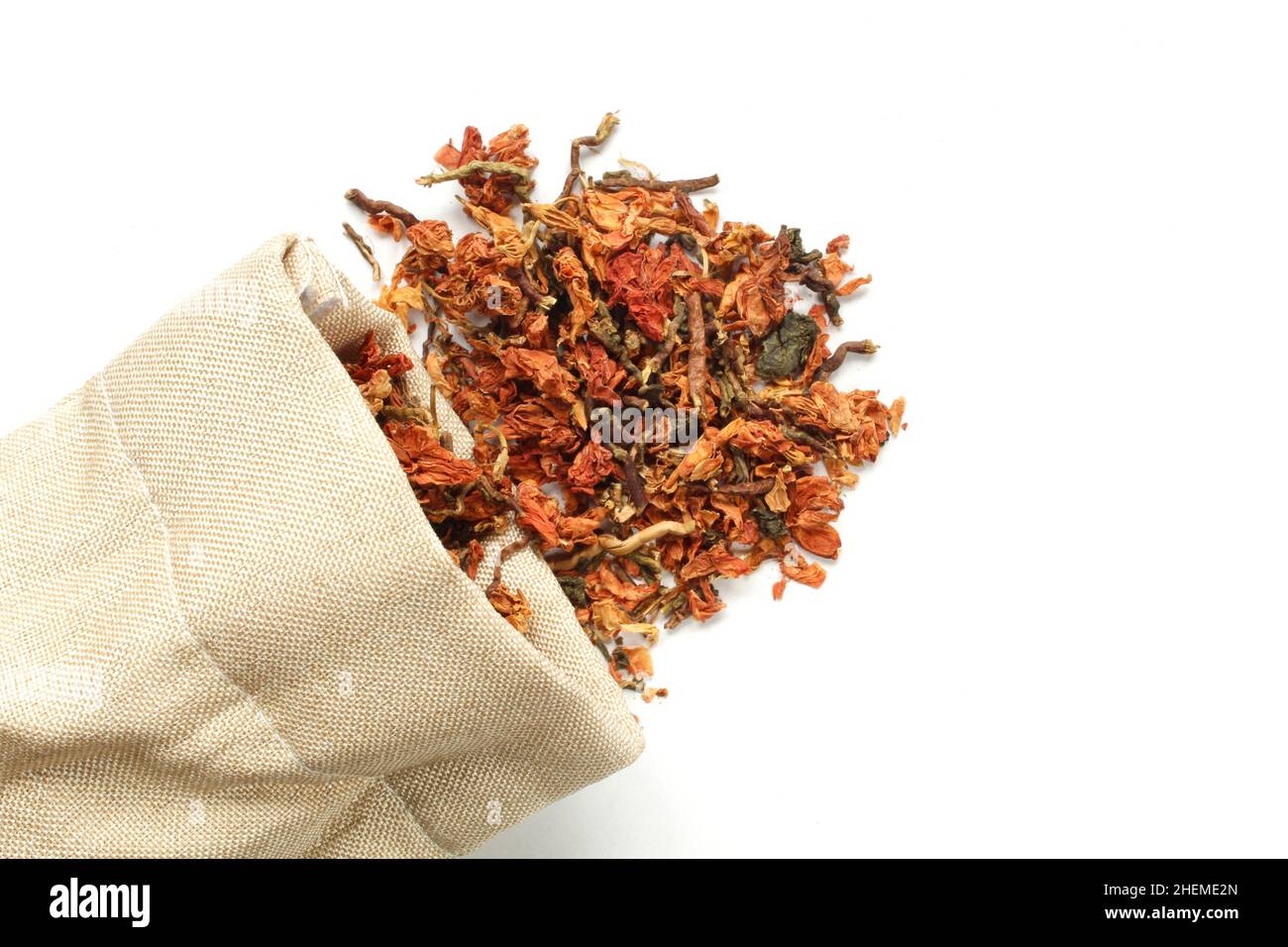 Mixture of dried spices spilling from brown burlap bag on white ...