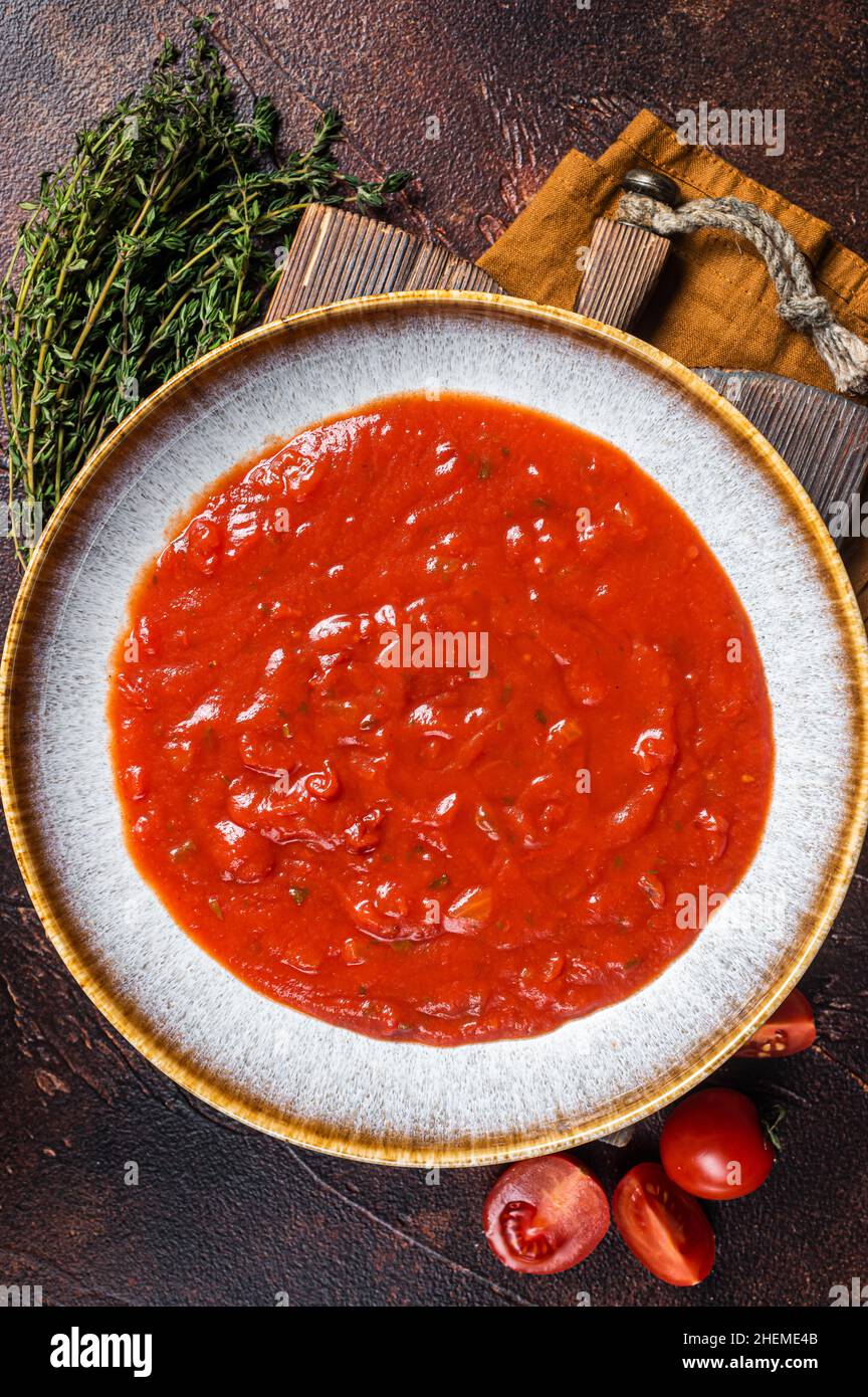 Homemade tomato Passata in rustic plate with herbs. Dark background ...