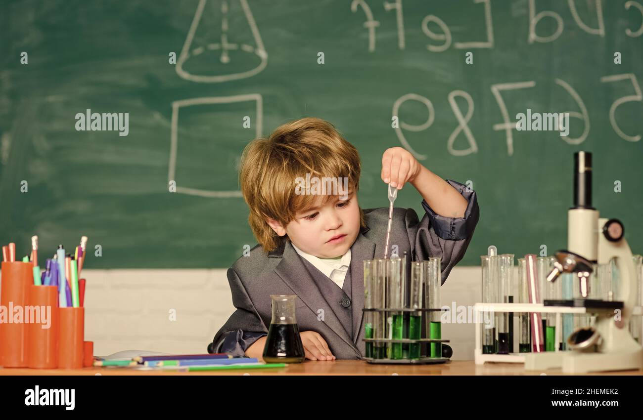 little boy at lesson. Back to school. Little boy is making science ...