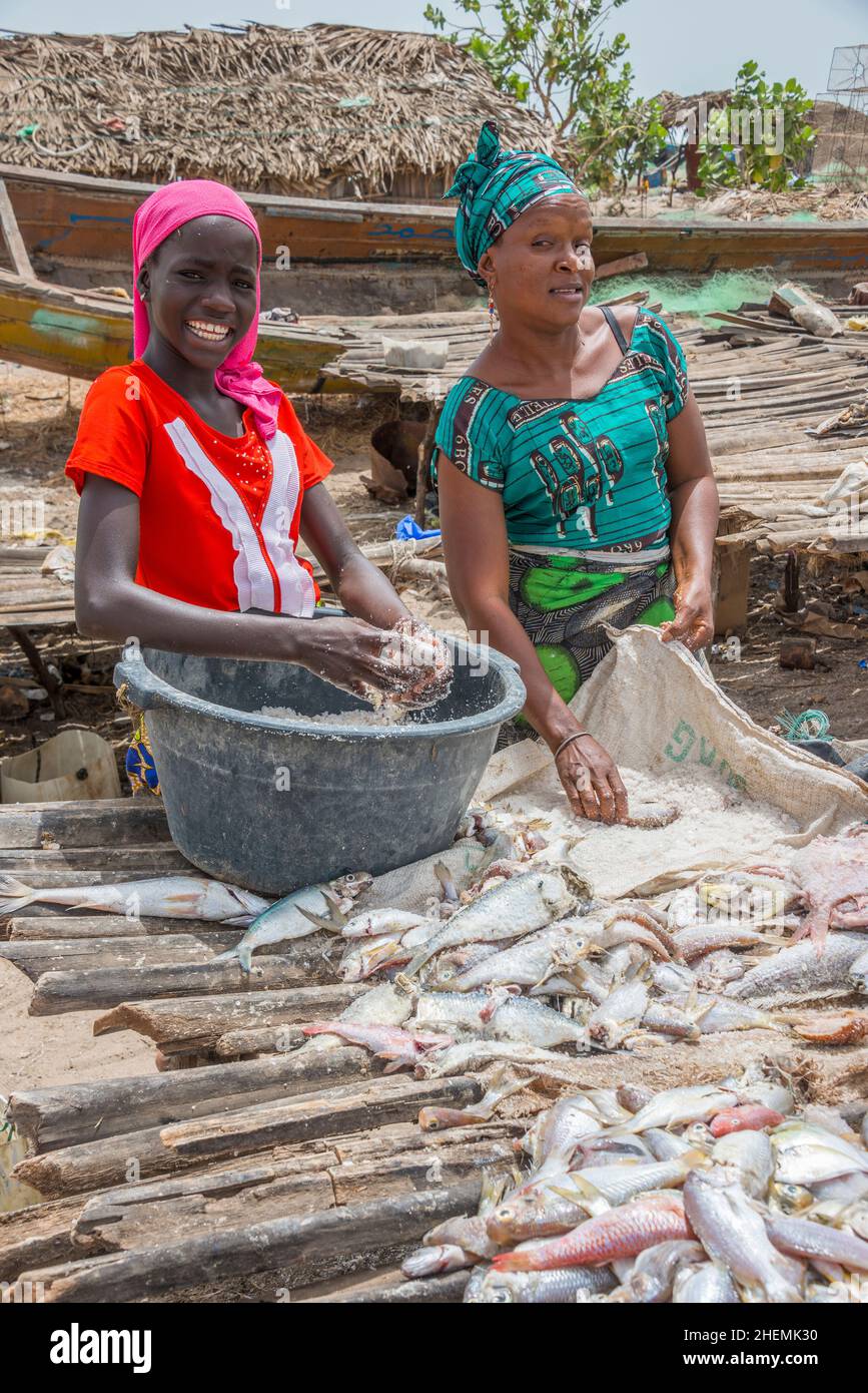 Mother and daughter at a fish drying facility on the beach at Sanyang ...