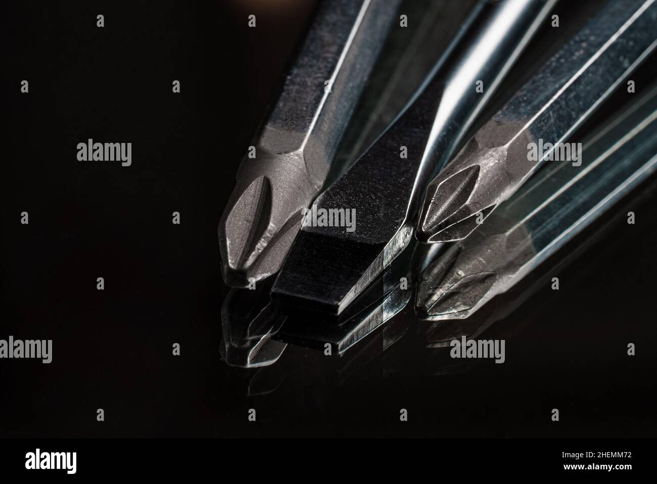 High angle closeup of collection of metal flat and cross screwdrivers ...