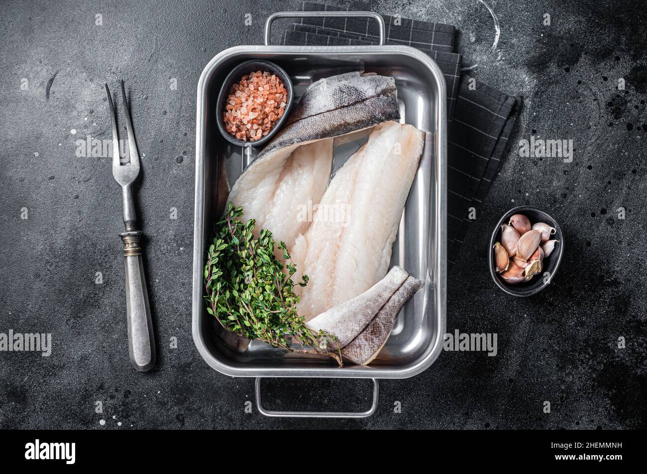 Raw haddock fish fillets, whitefish meat in kitchen tray with thyme ...