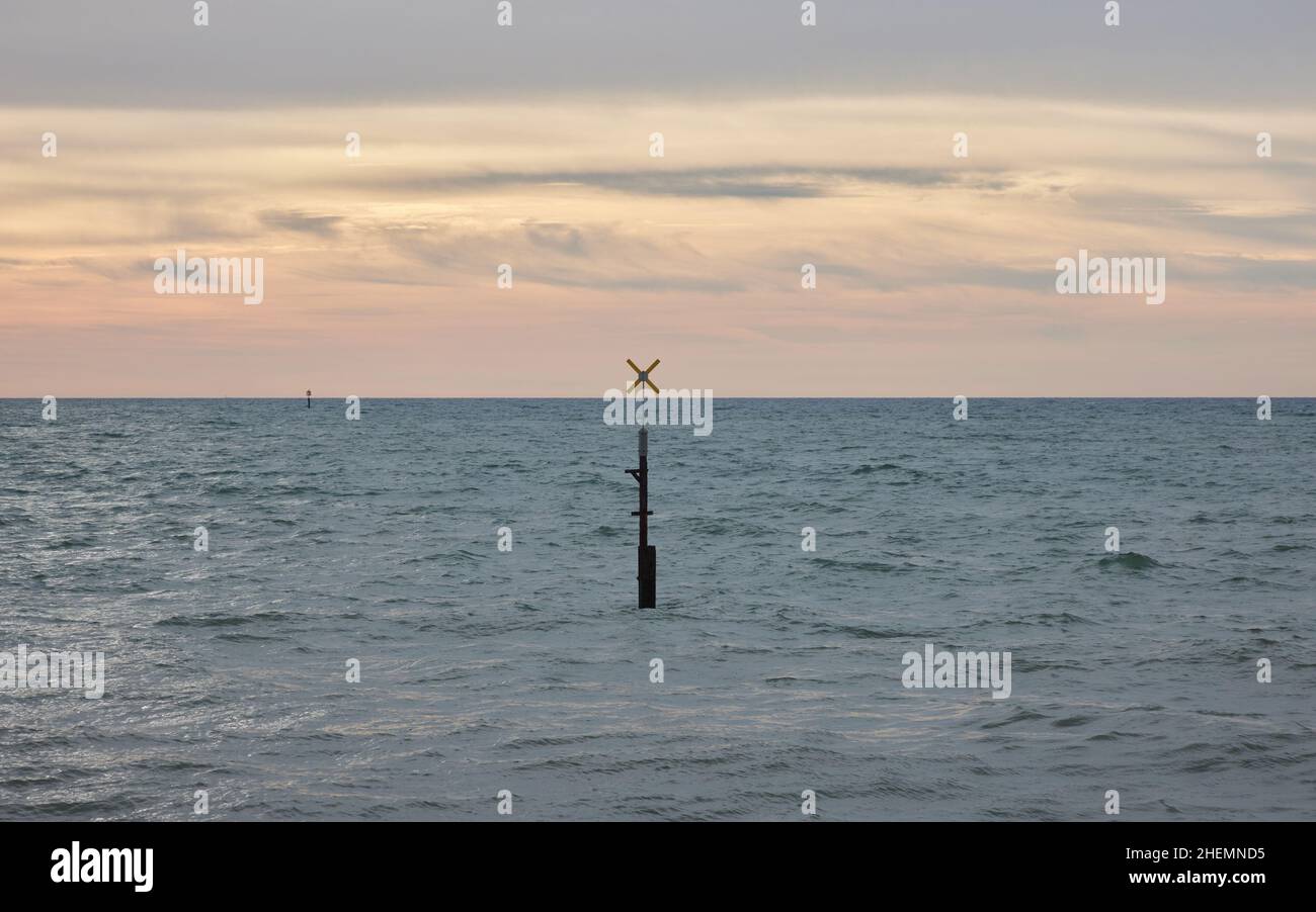 Large warning post seen in the sea of the coast Stock Photo - Alamy