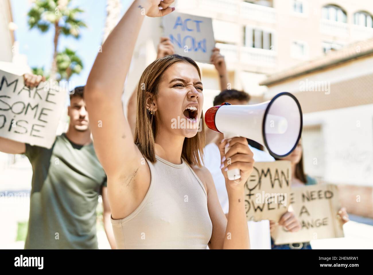 Group of young hispanic activists protesting holding banner and using ...