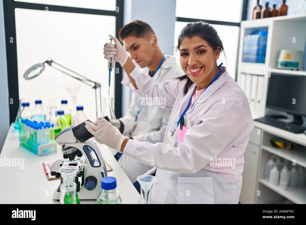 Man and woman scientists partners using pipette at laboratory Stock ...