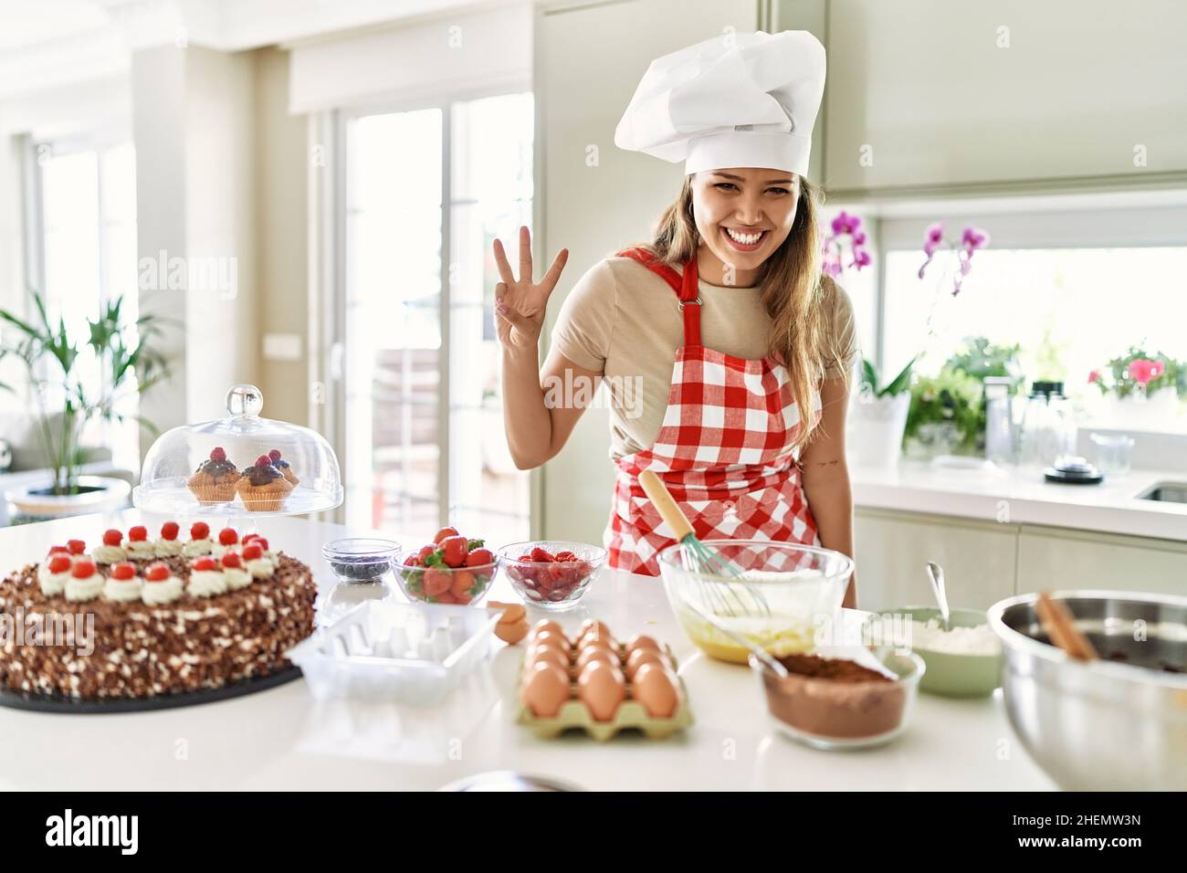 Beautiful young brunette pastry chef woman cooking pastries at the ...