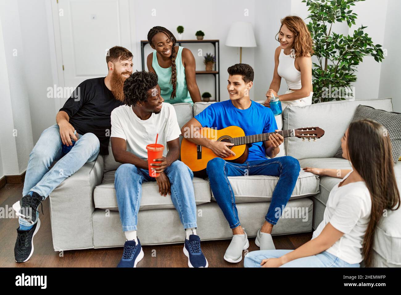 Group of young friends smiling happy and playing classical guitar at ...