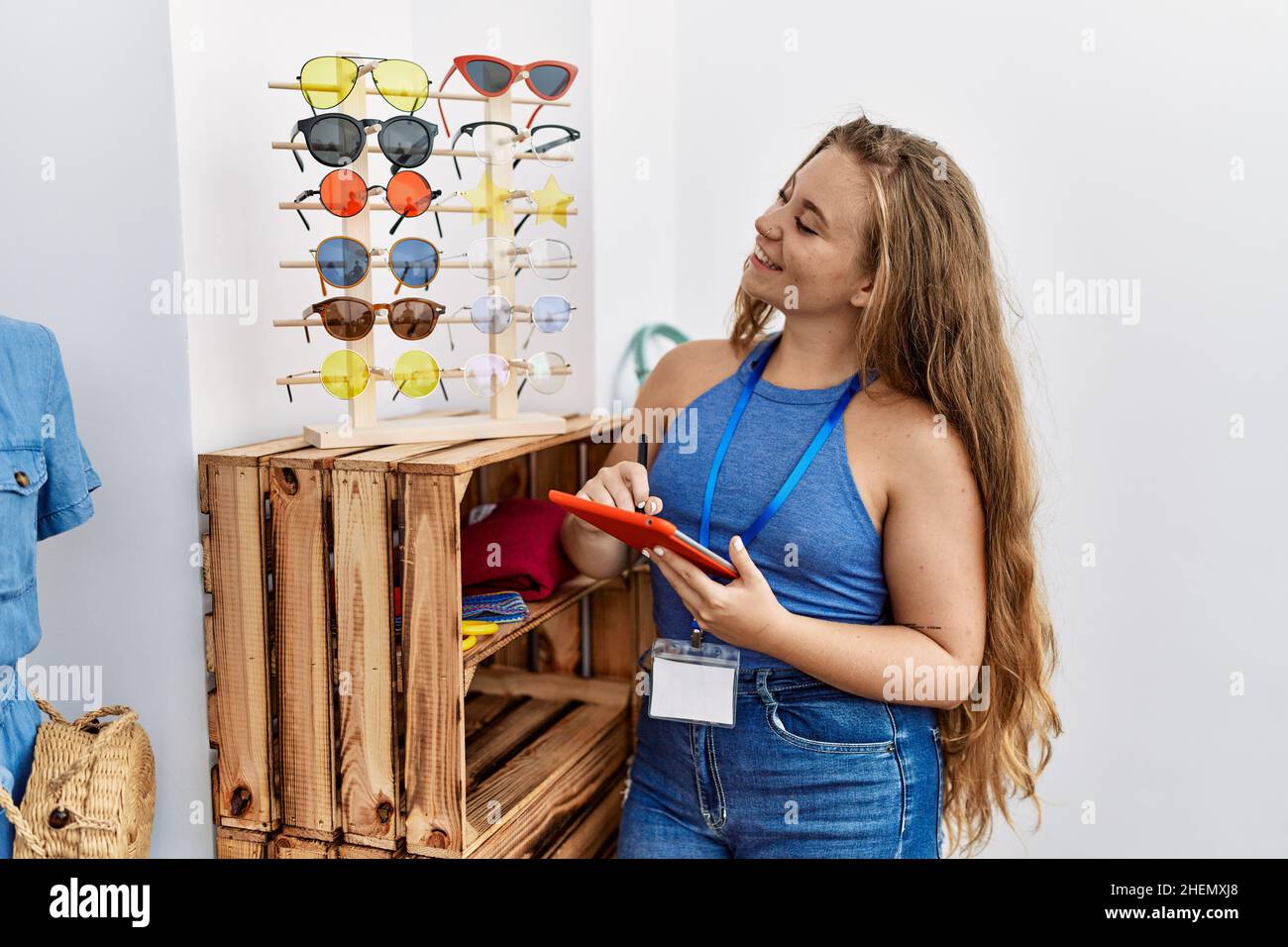 Young blonde girl using touchpad working at clothing store Stock Photo ... Young blonde girl using touchpad working at clothing store Stock Photo ...