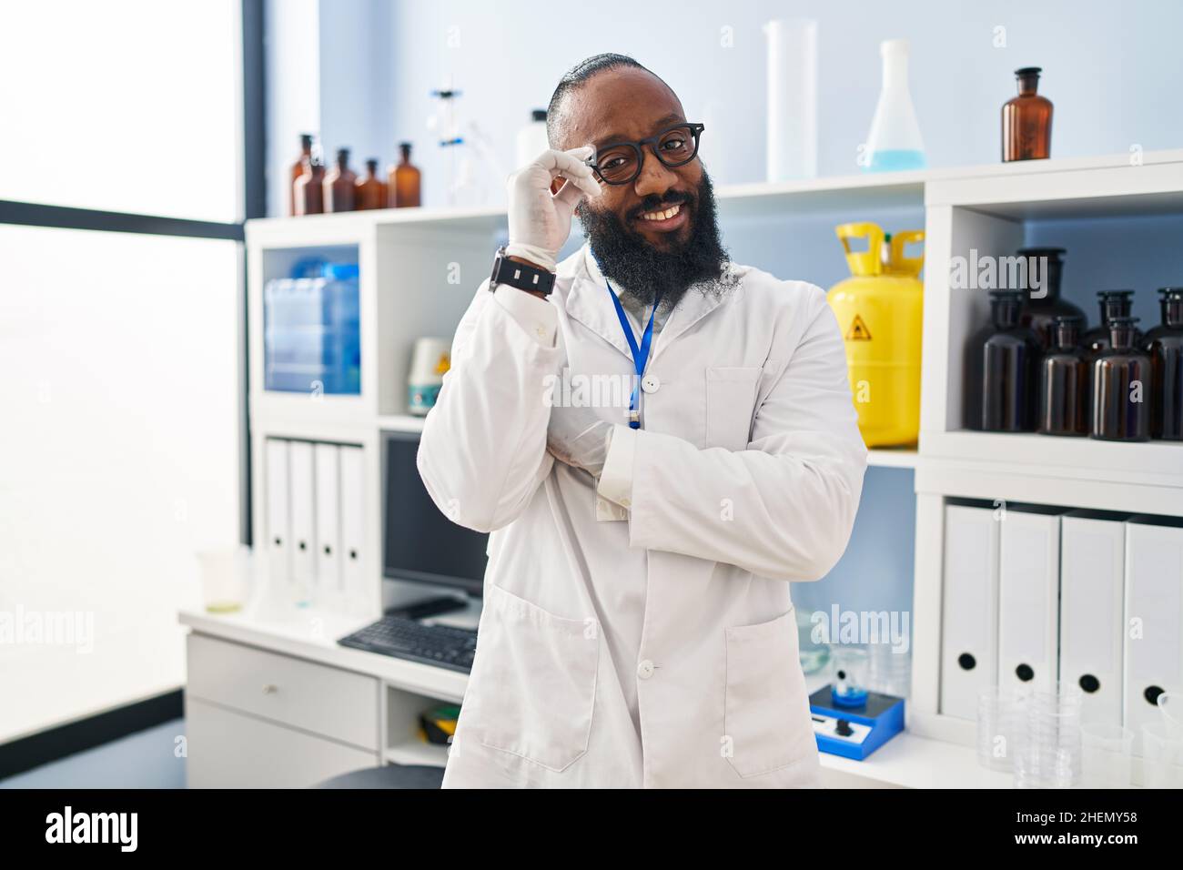 Young african american man wearing scientist uniform standing at ...