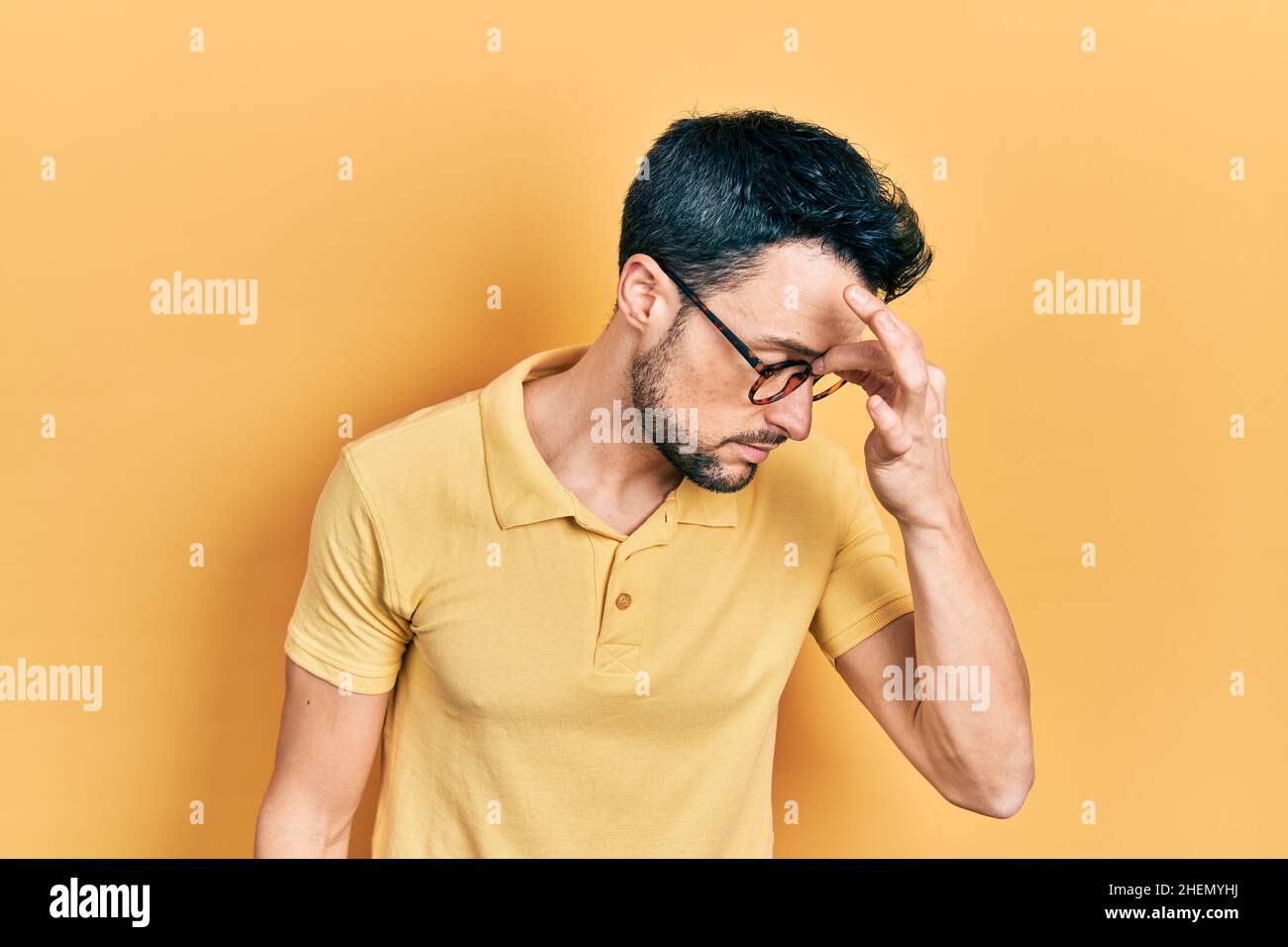 Young hispanic man wearing casual clothes and glasses tired rubbing ...