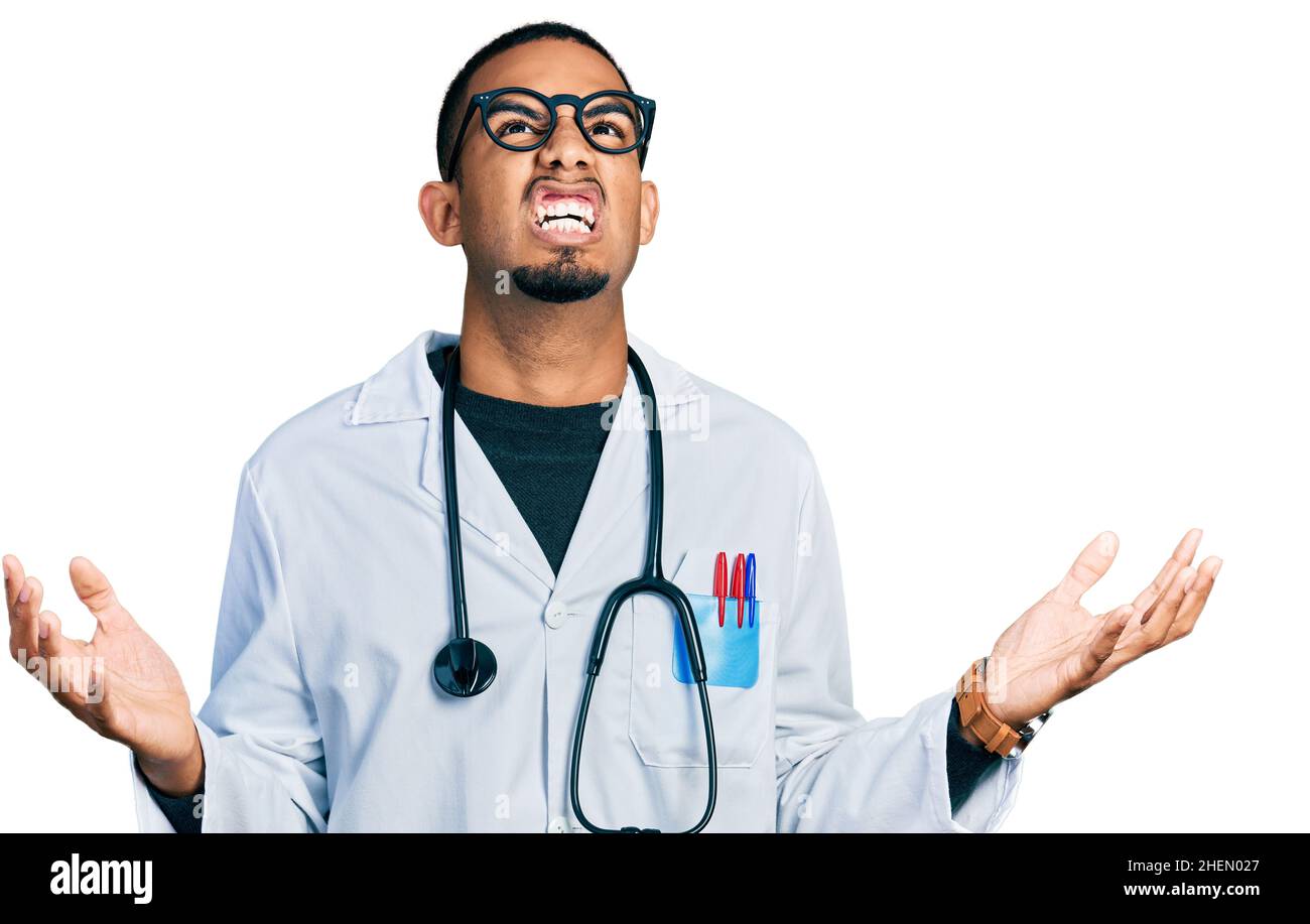 Young african american man wearing doctor uniform and stethoscope crazy ...