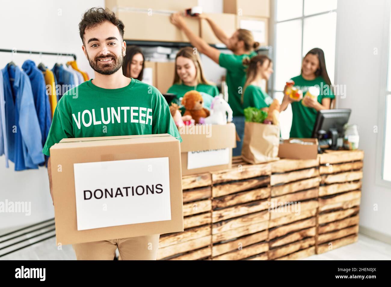 Group of young volunteers working at charity center. Man smiling happy ...