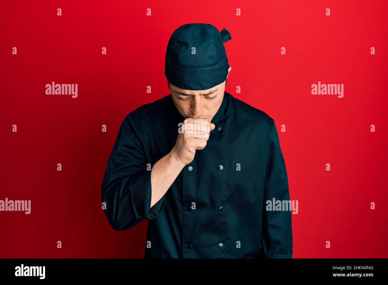 Handsome young man wearing professional cook uniform and hat feeling ...