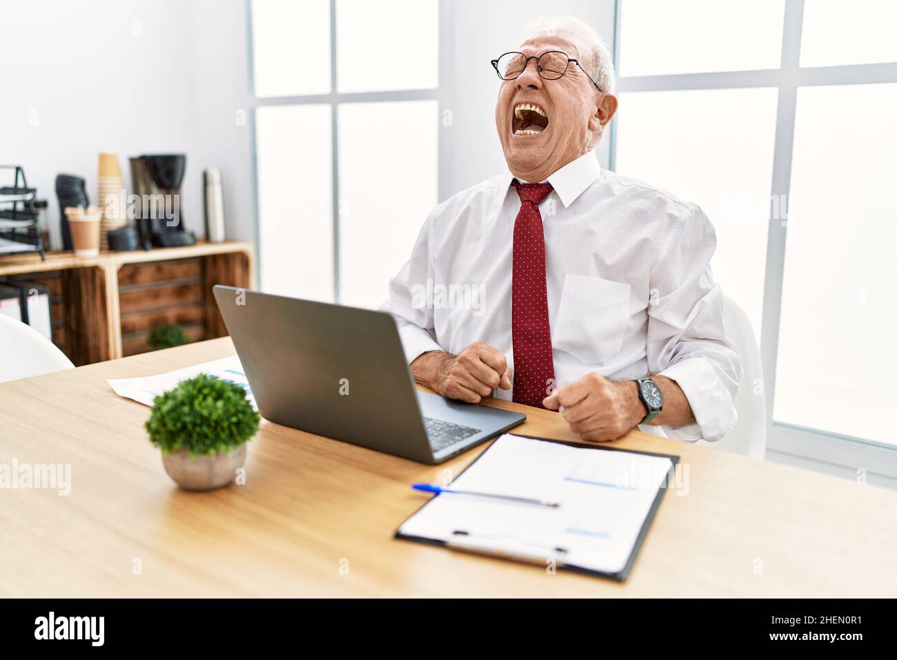 Senior man working at the office using computer laptop angry and mad ...