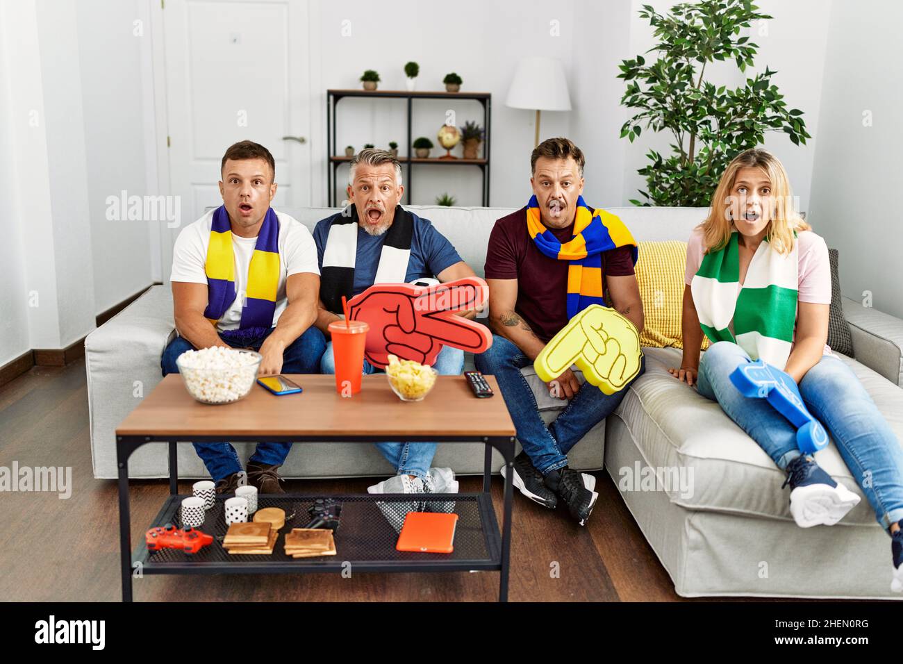 Group of middle age people wearing team scarf cheering football game ...