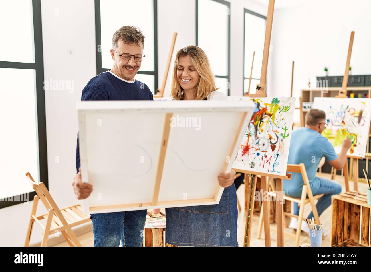 Group of middle age people drawing at art studio. Two students smiling ...