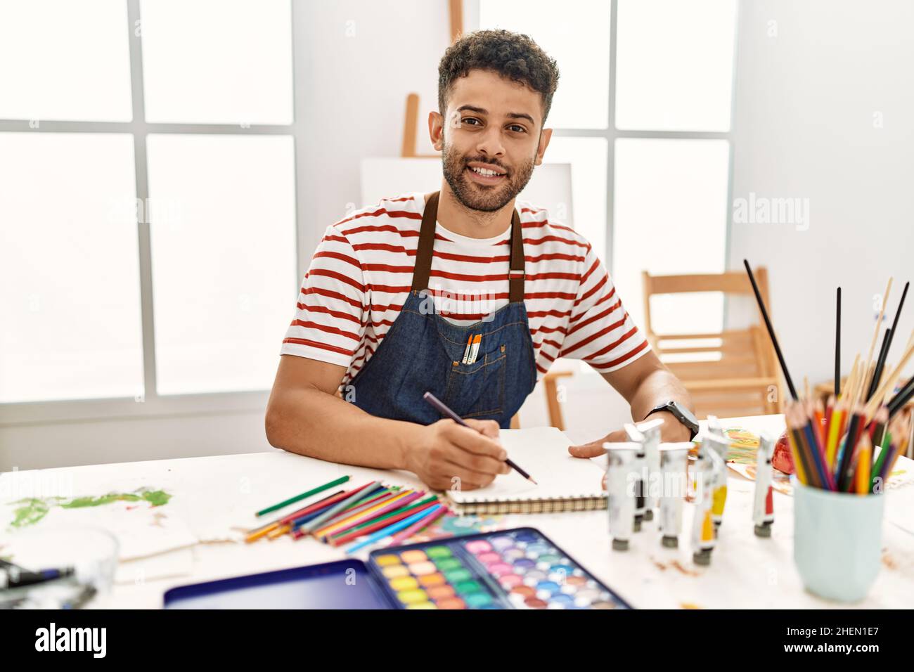 Young arab artist man smiling happy drawing at art studio Stock Photo ...