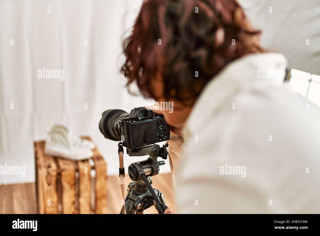 Young hispanic photographer woman on back view using camera at photo ...