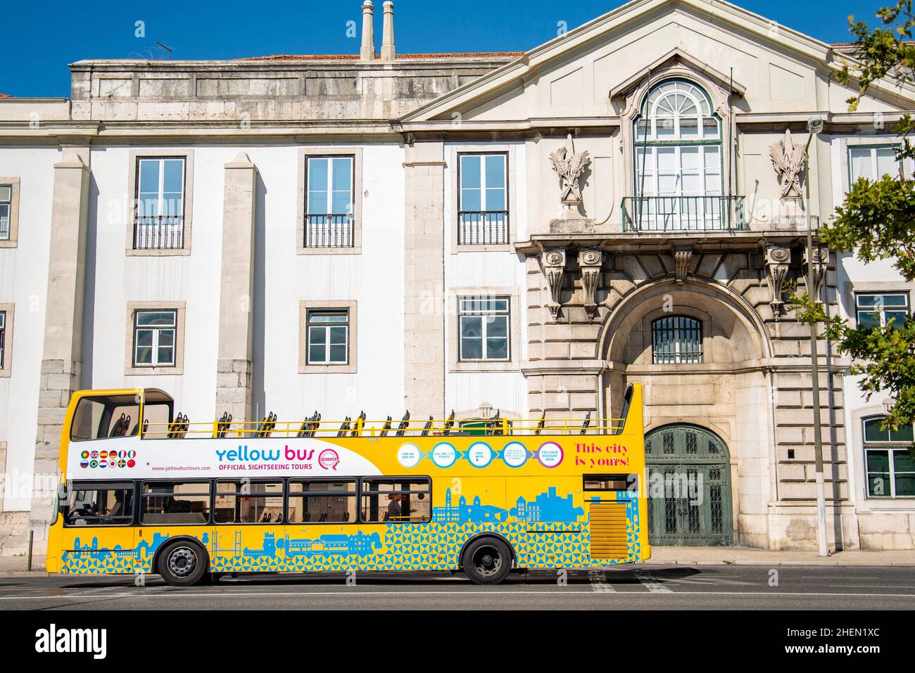 a Tourist Bus of Yellow bus in front of the Old Town Alfama of the city ...