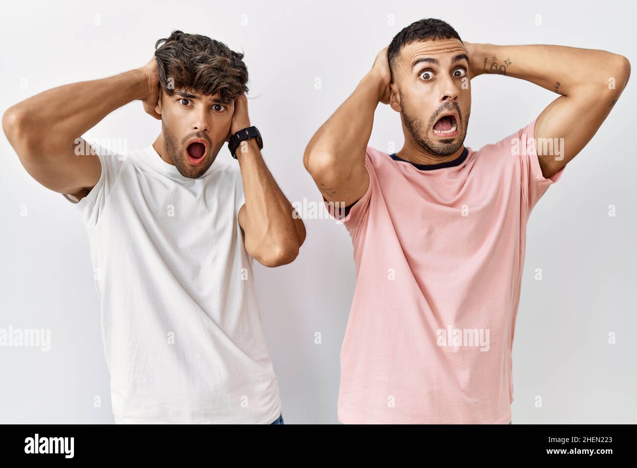 Young gay couple standing over isolated background crazy and scared ...
