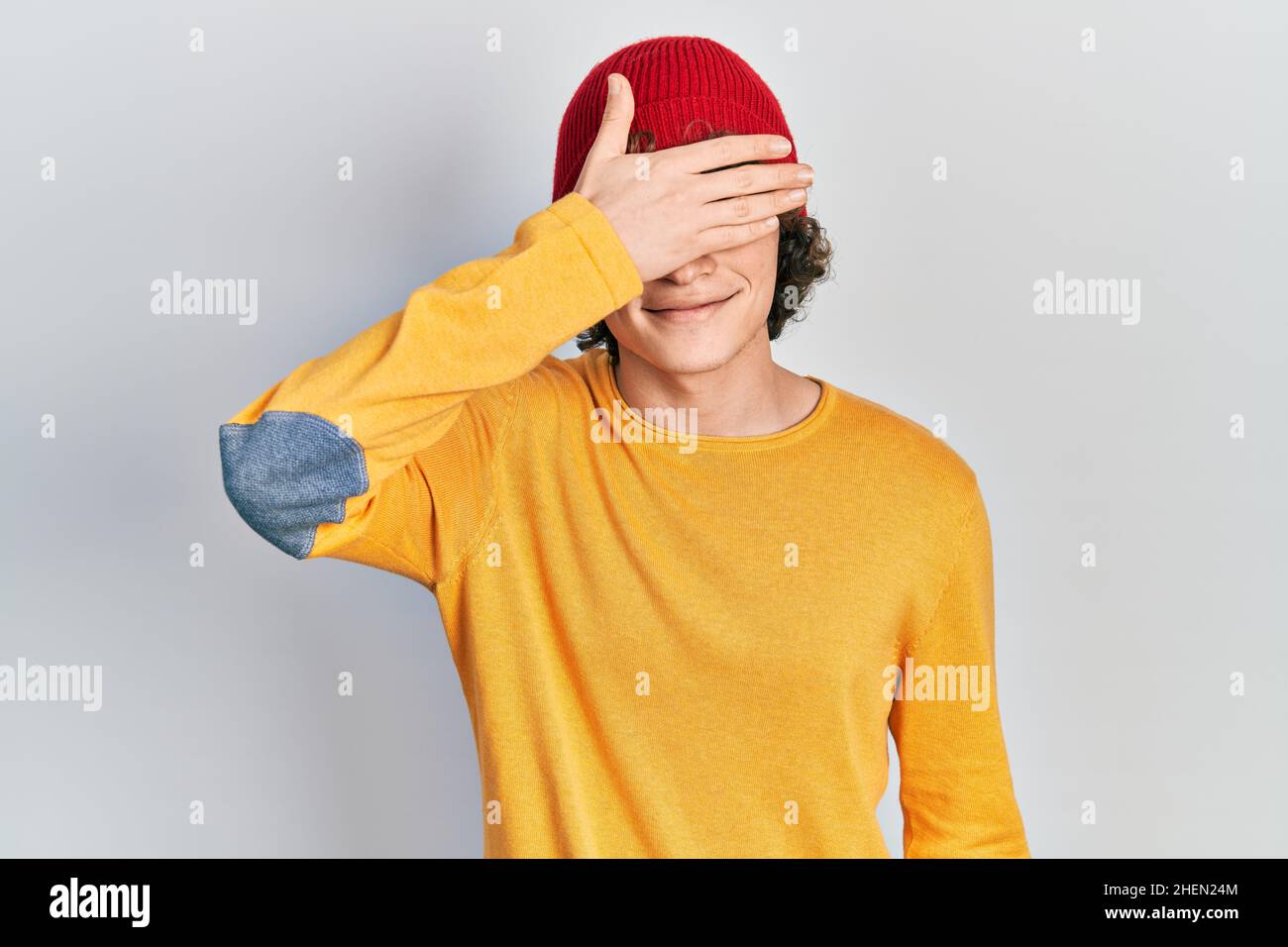 Handsome young man wearing wool hat smiling and laughing with hand on ...