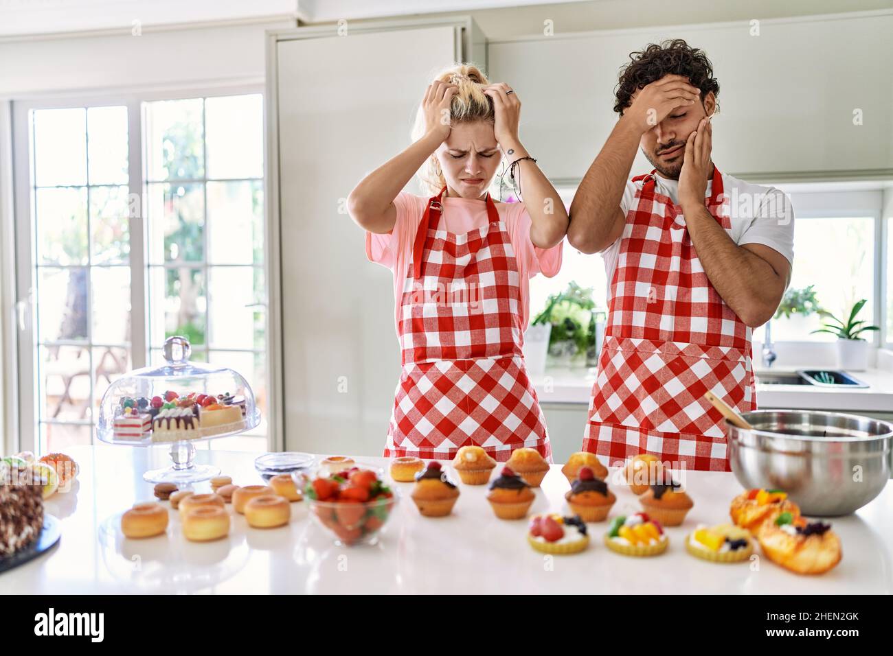 Couple of wife and husband cooking pastries at the kitchen suffering ...