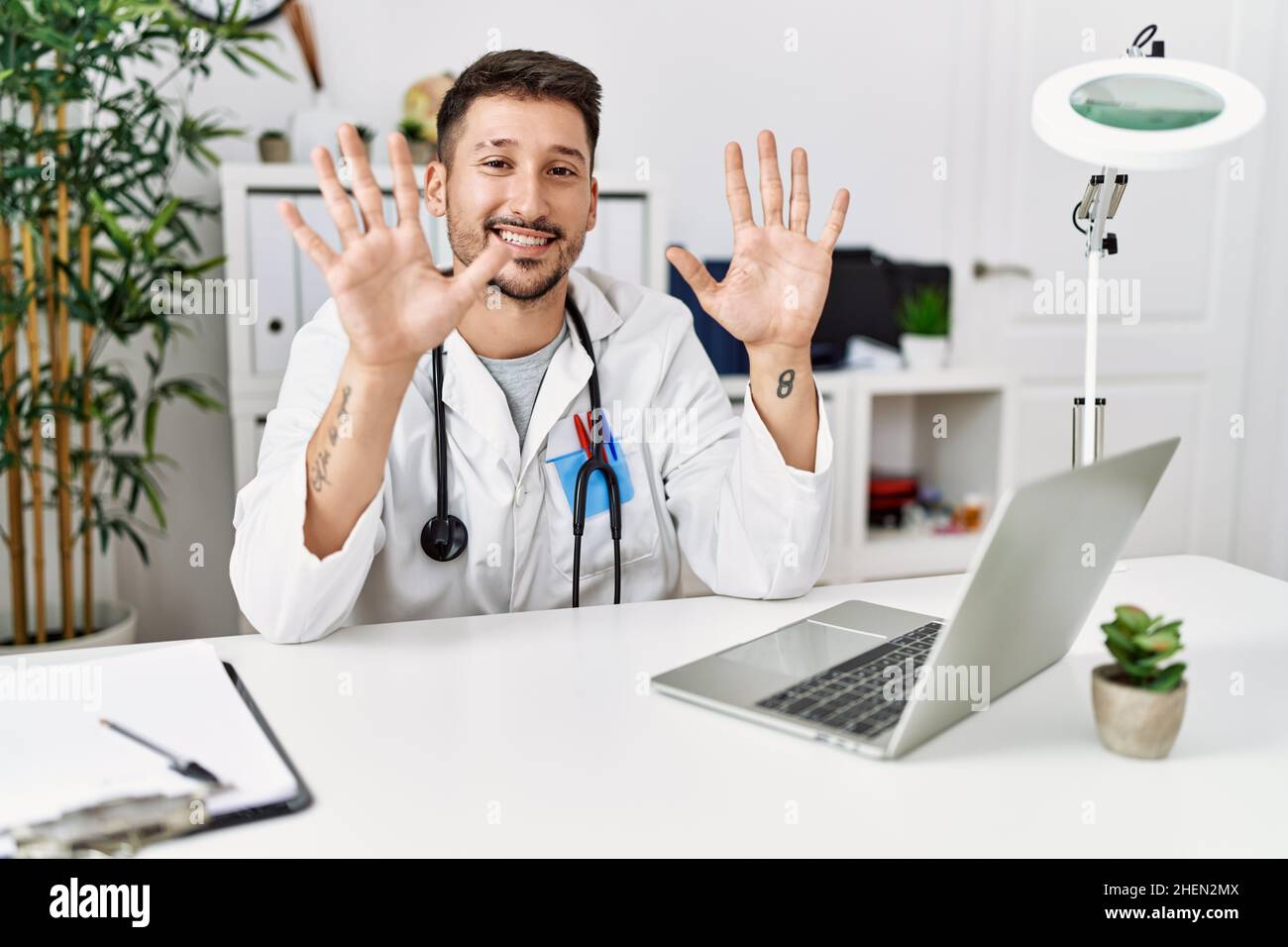 Young doctor working at the clinic using computer laptop showing and ...