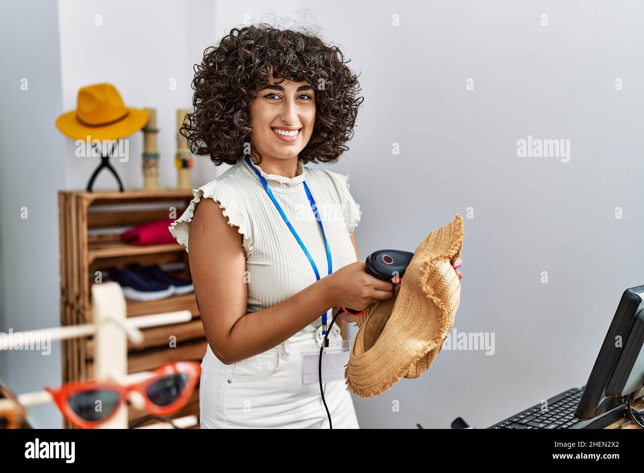 Young middle east shopkeeper woman smiling happy working at clothing ...