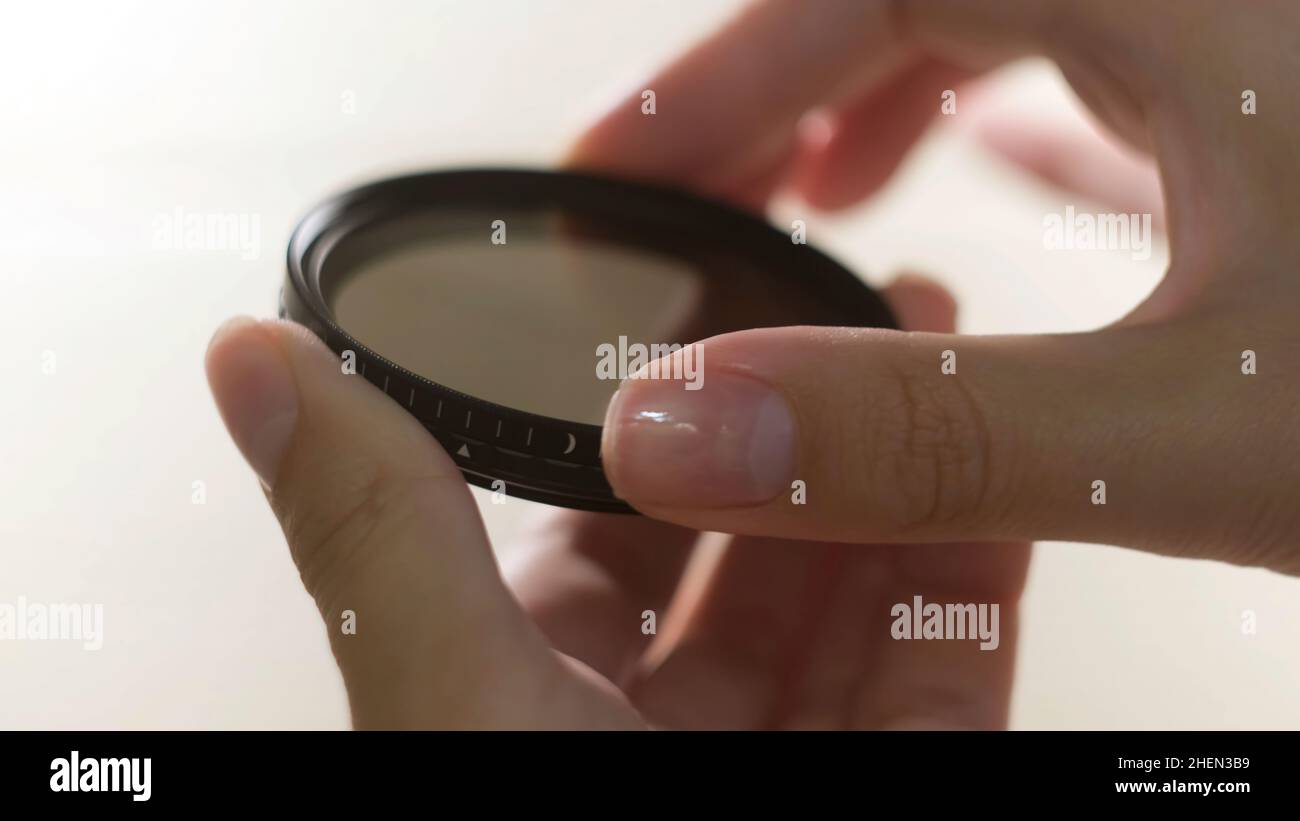 Close up of polarizing lens filter in girls hands isolated on white ...