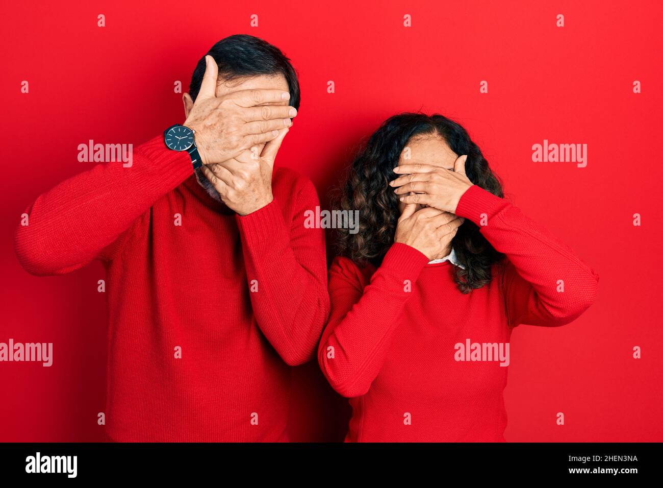 Middle age couple of hispanic woman and man hugging and standing ...