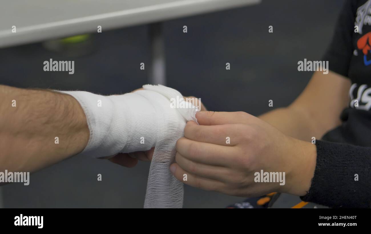 Professional fighter in the locker room puts bandage on the hand before ...