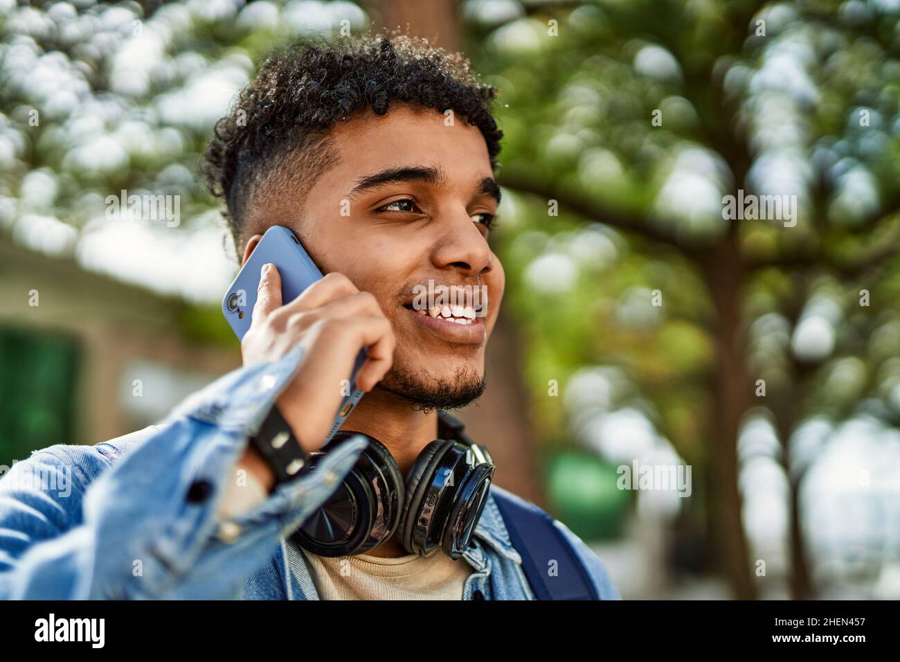 Hispanic young man speaking on the phone at the university campus Stock ...